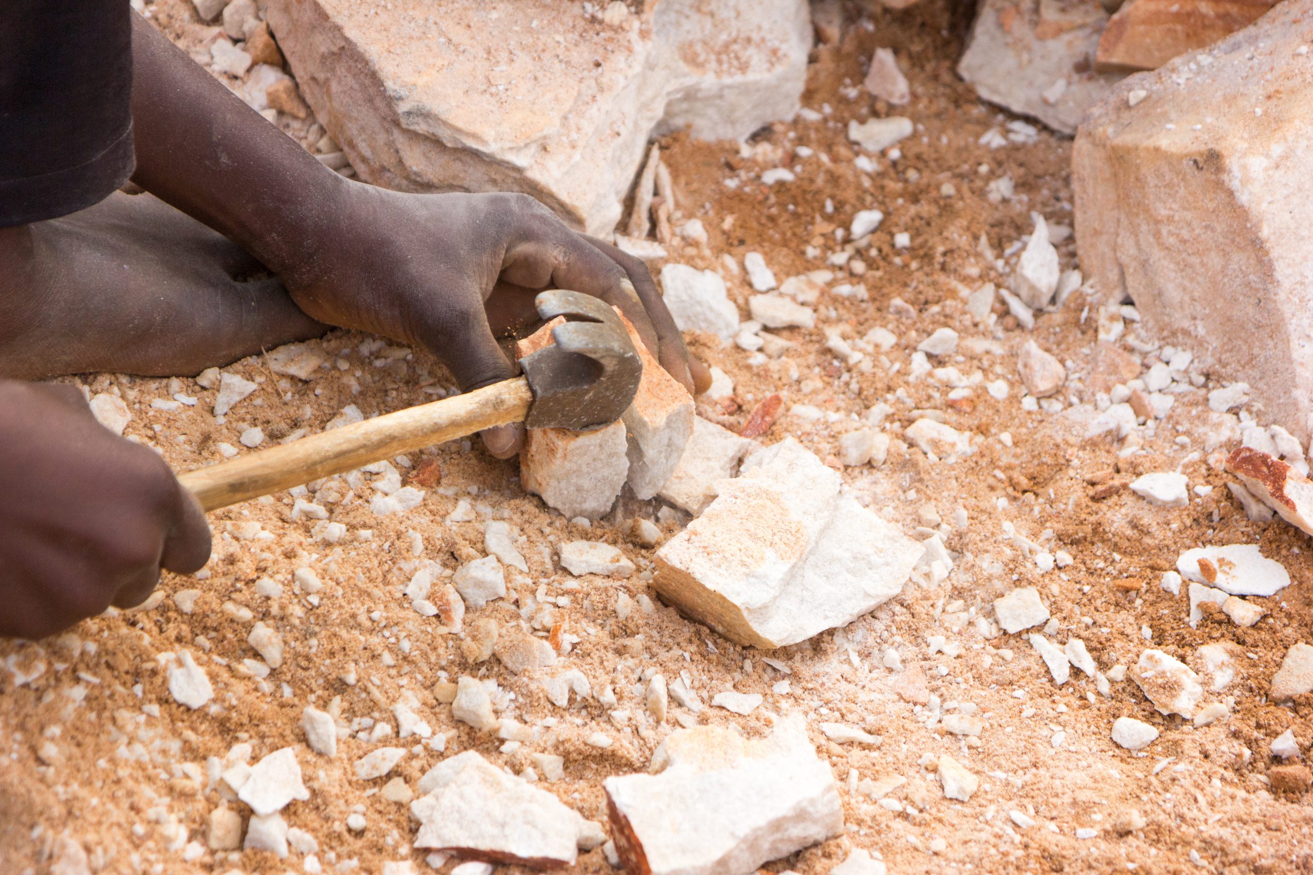 Ugandan,Child's,Hands,Breaking,Rocks,Into,Small,Slabs,For,His - Humanium