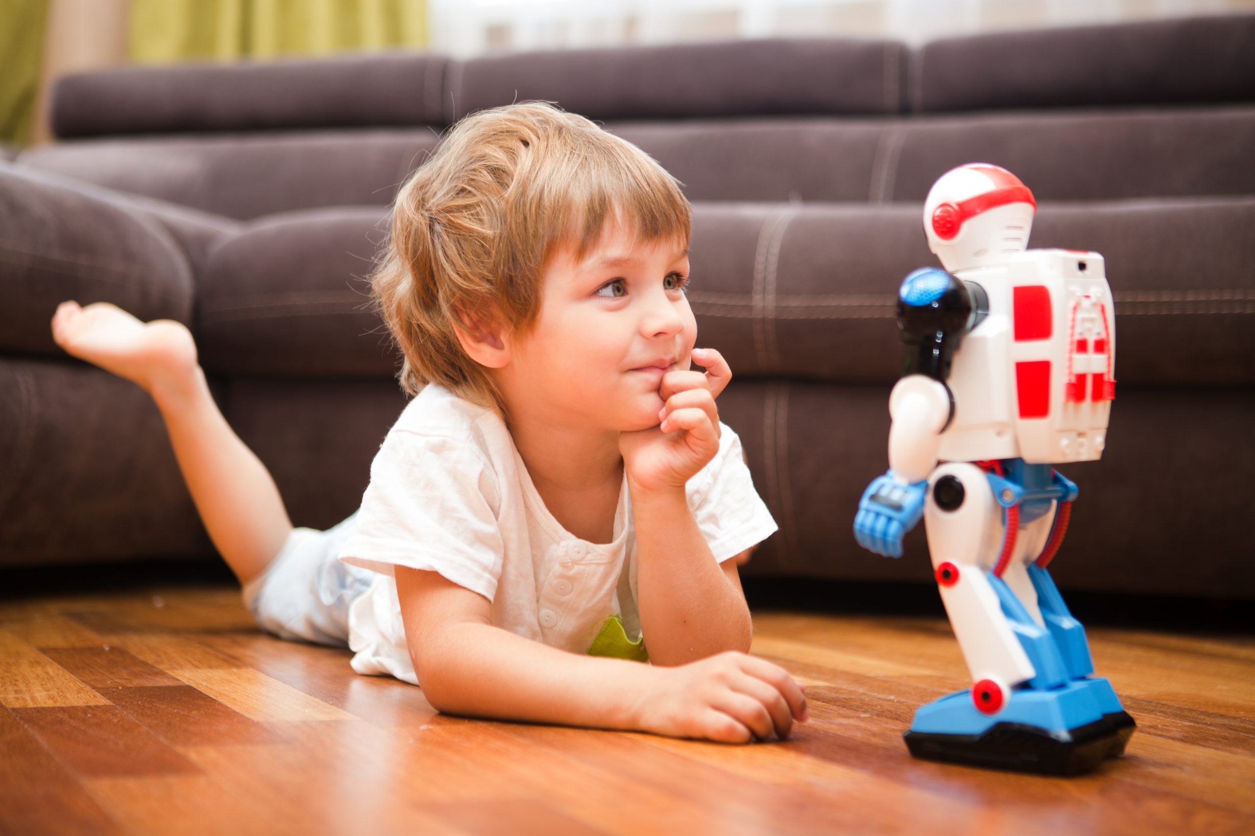 Little,Boy,Playing,With,Robot,Toy,At,Home - Humanium